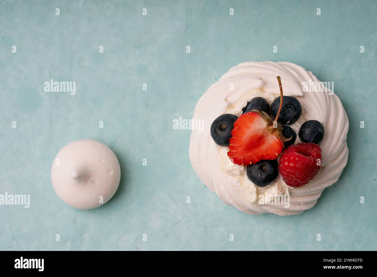 Top view of a pavlova dessert with whipped cream, strawberry, blueberry ...