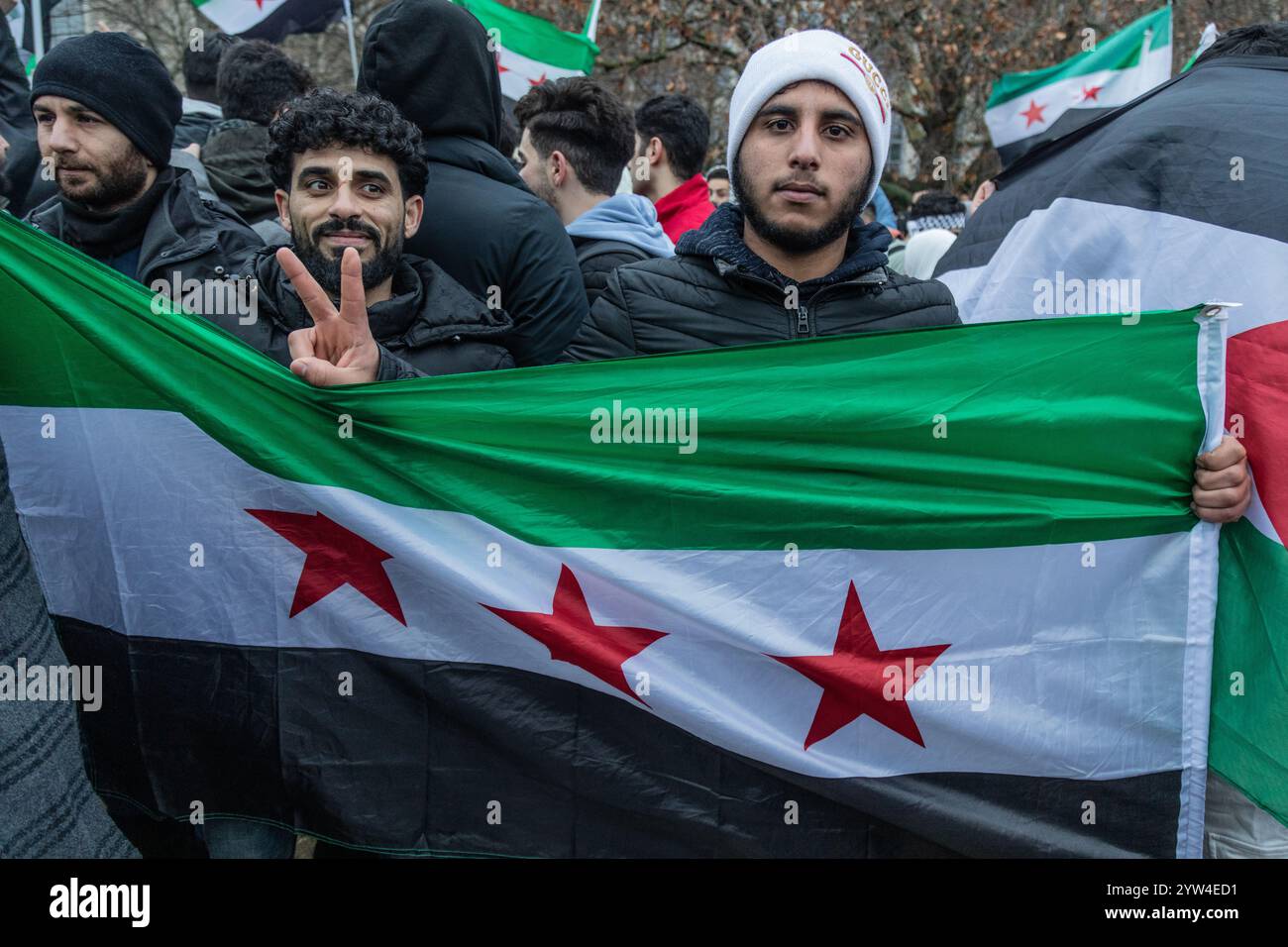 Berlin, Germany. 08th Dec, 2024. Two young men hold up a Free Syrian ...