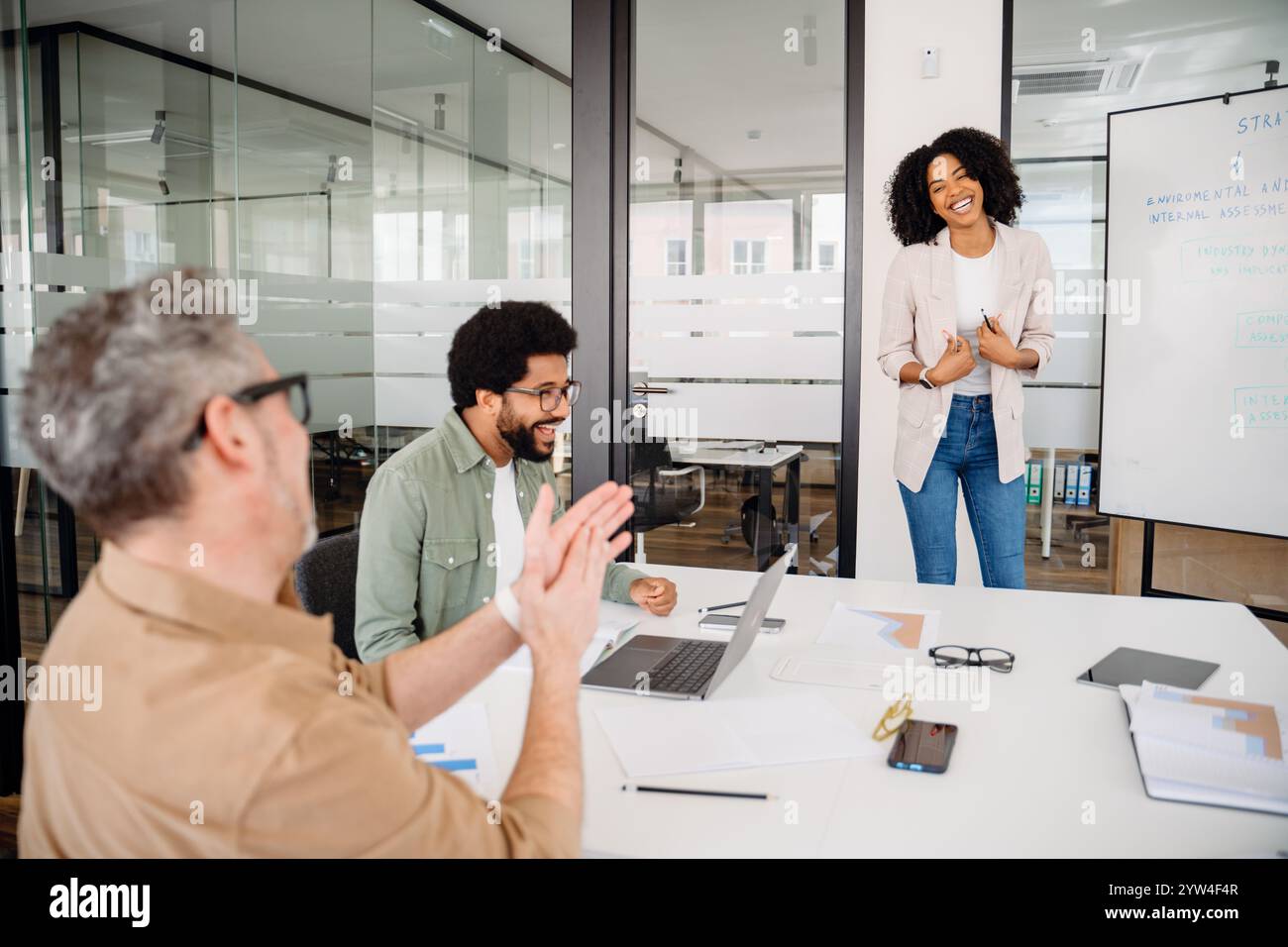 Laughter fills a modern office as colleagues share a joyous moment, the ...