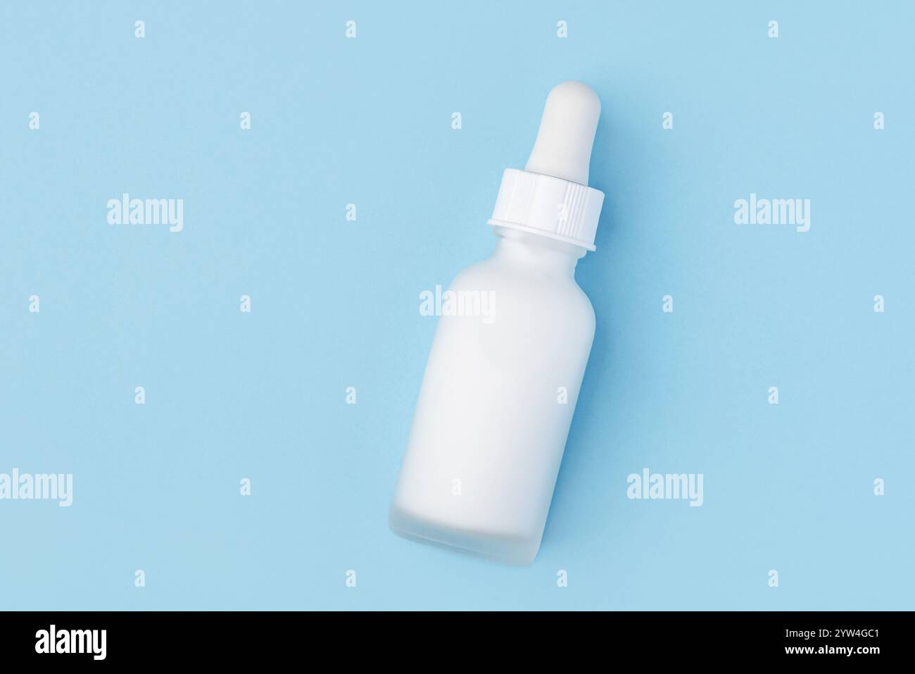 A frosted white dropper bottle with a minimalist design on a pastel ...