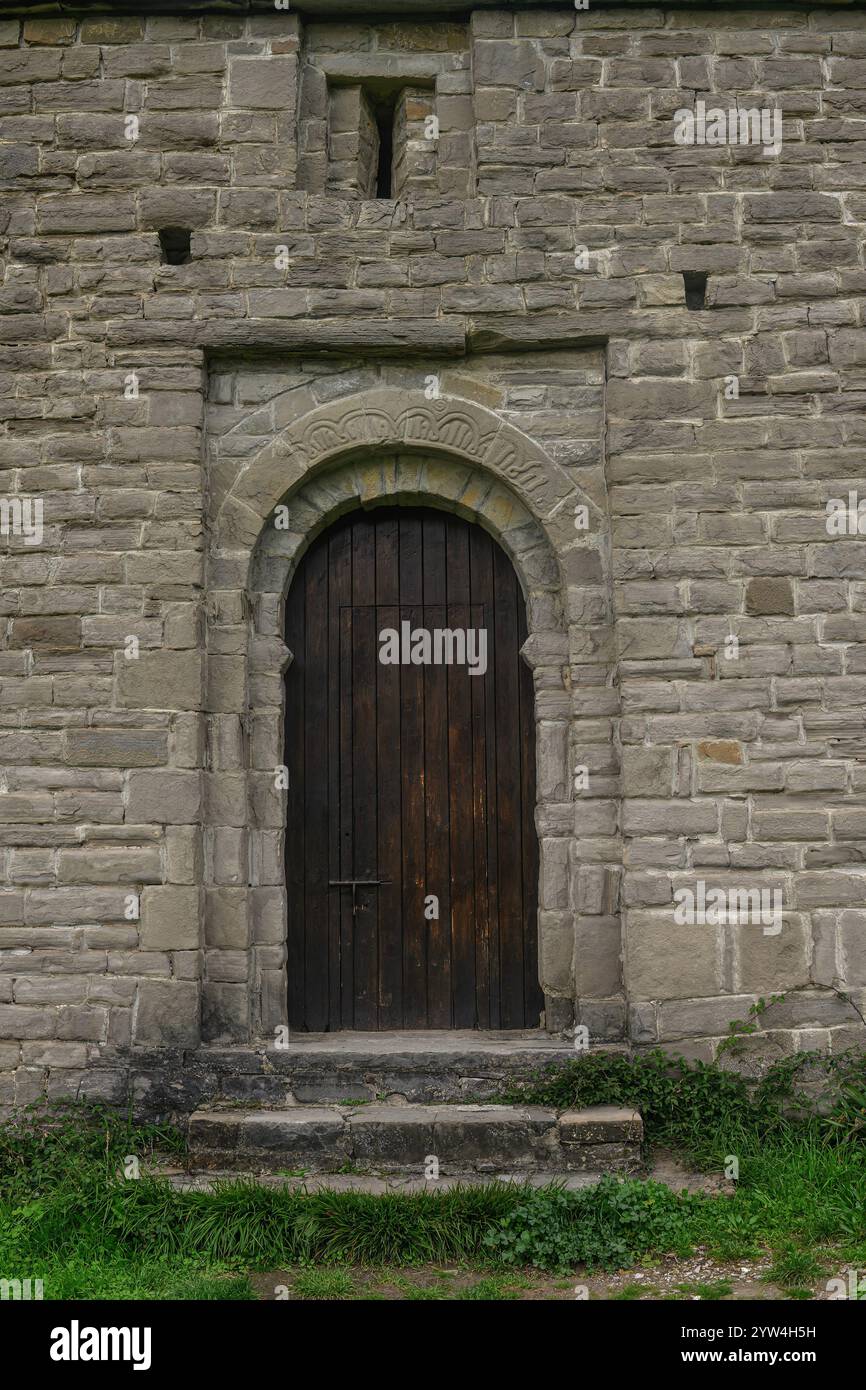 Stone chapel with a rustic design, set in a green field with a ...