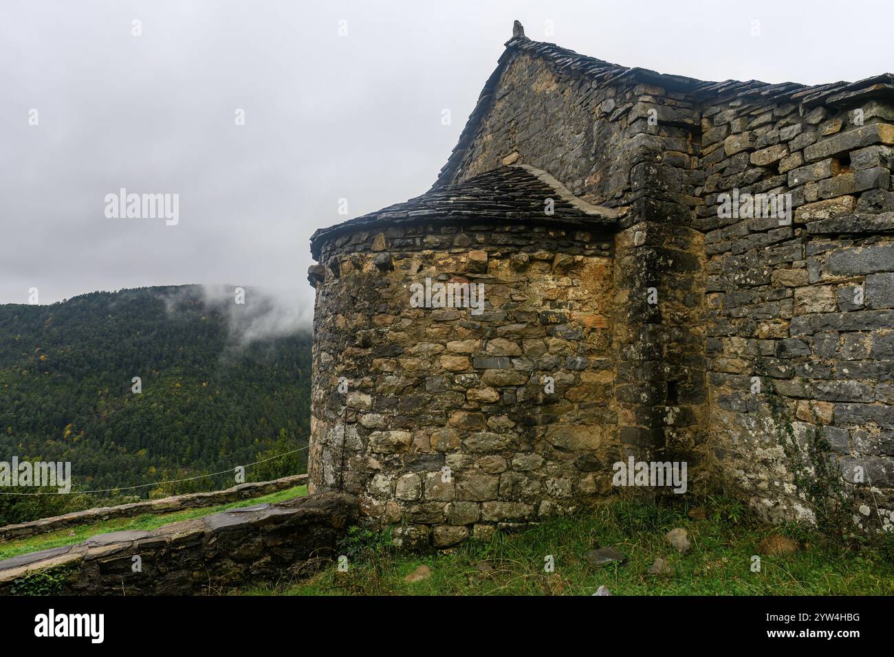 Romanesque stone church undergoing restoration, located in a lush rural ...