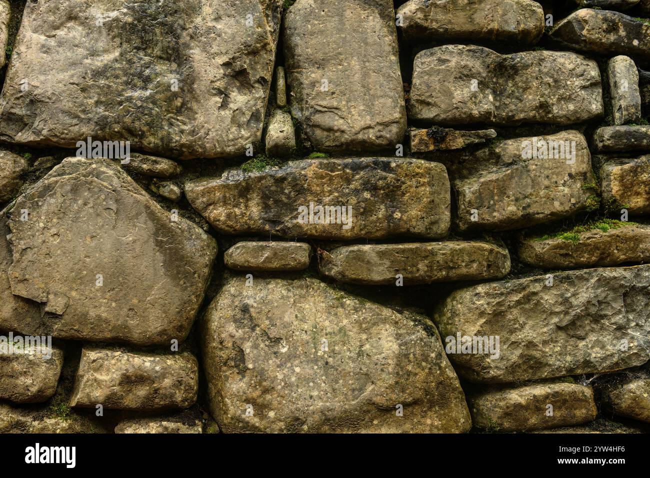 Rustic stone wall with patches of vibrant green moss Stock Photo - Alamy