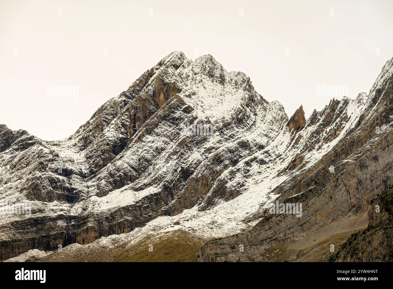 Close-up view of a dramatic snow-dusted mountain peak with sharp ridges ...
