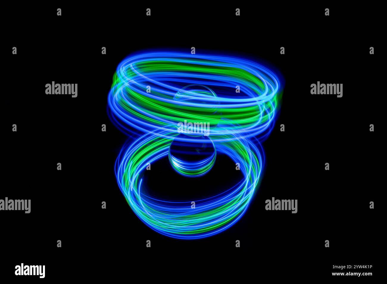 Abstract blue and green light trails created by light painting around a ...
