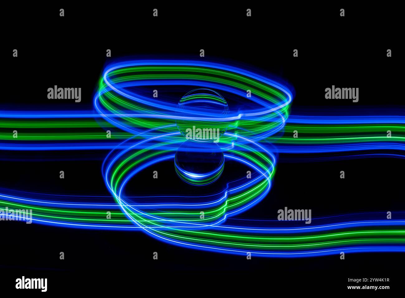 Abstract blue and green light trails created by light painting around a ...