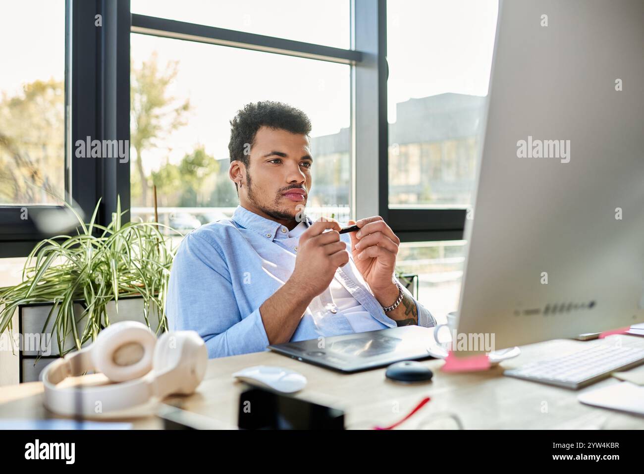 Handsome man deep in thought at a sleek desk, engaging with his ...
