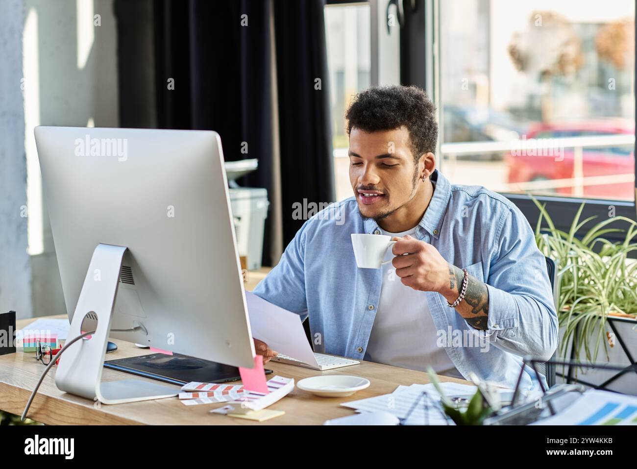 This charming man sips coffee at his modern, green filled workspace ...