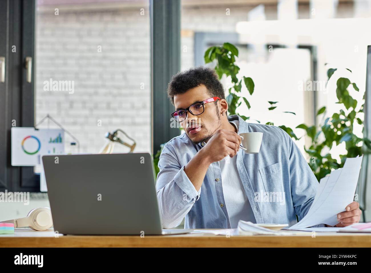 Handsome man reviews important documents with coffee in hand at a ...