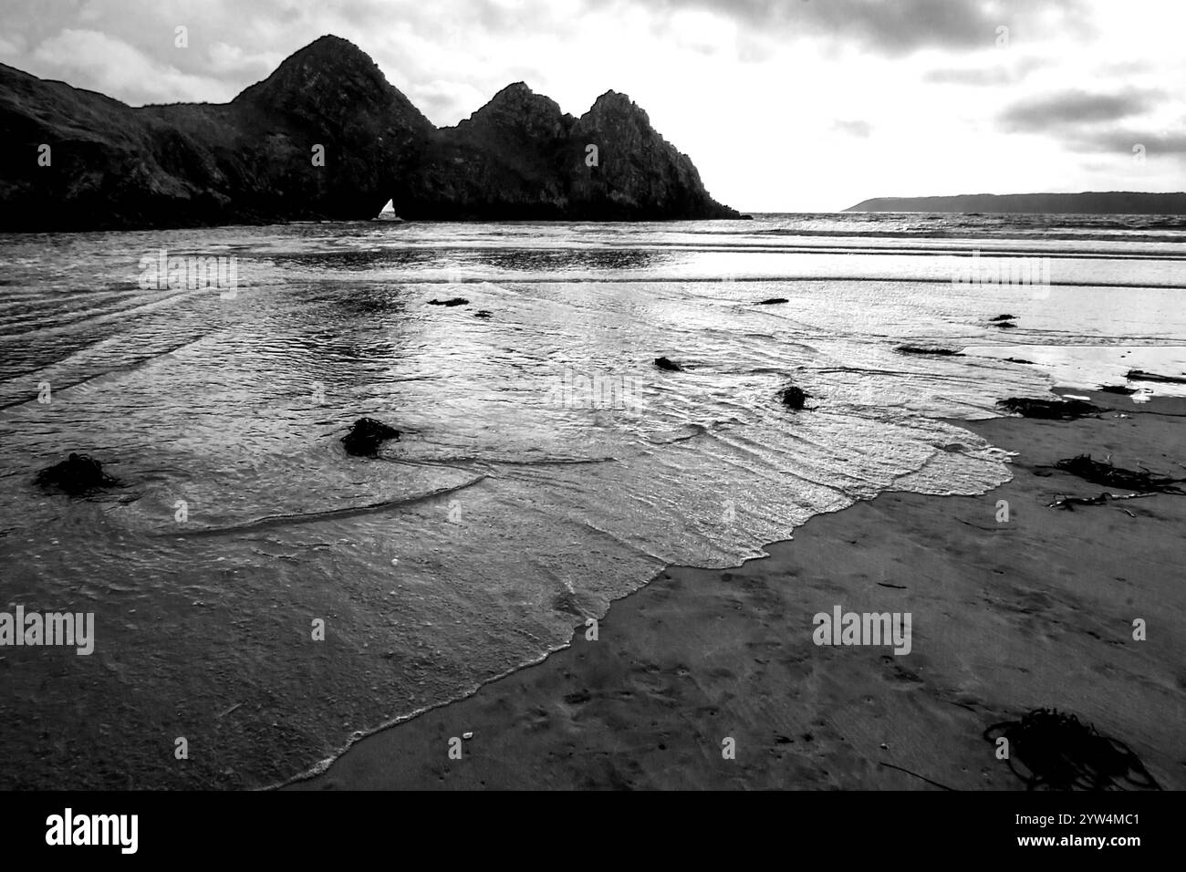 Dramatic black and white landscape at Three Cliffs Beach in Wales with ...
