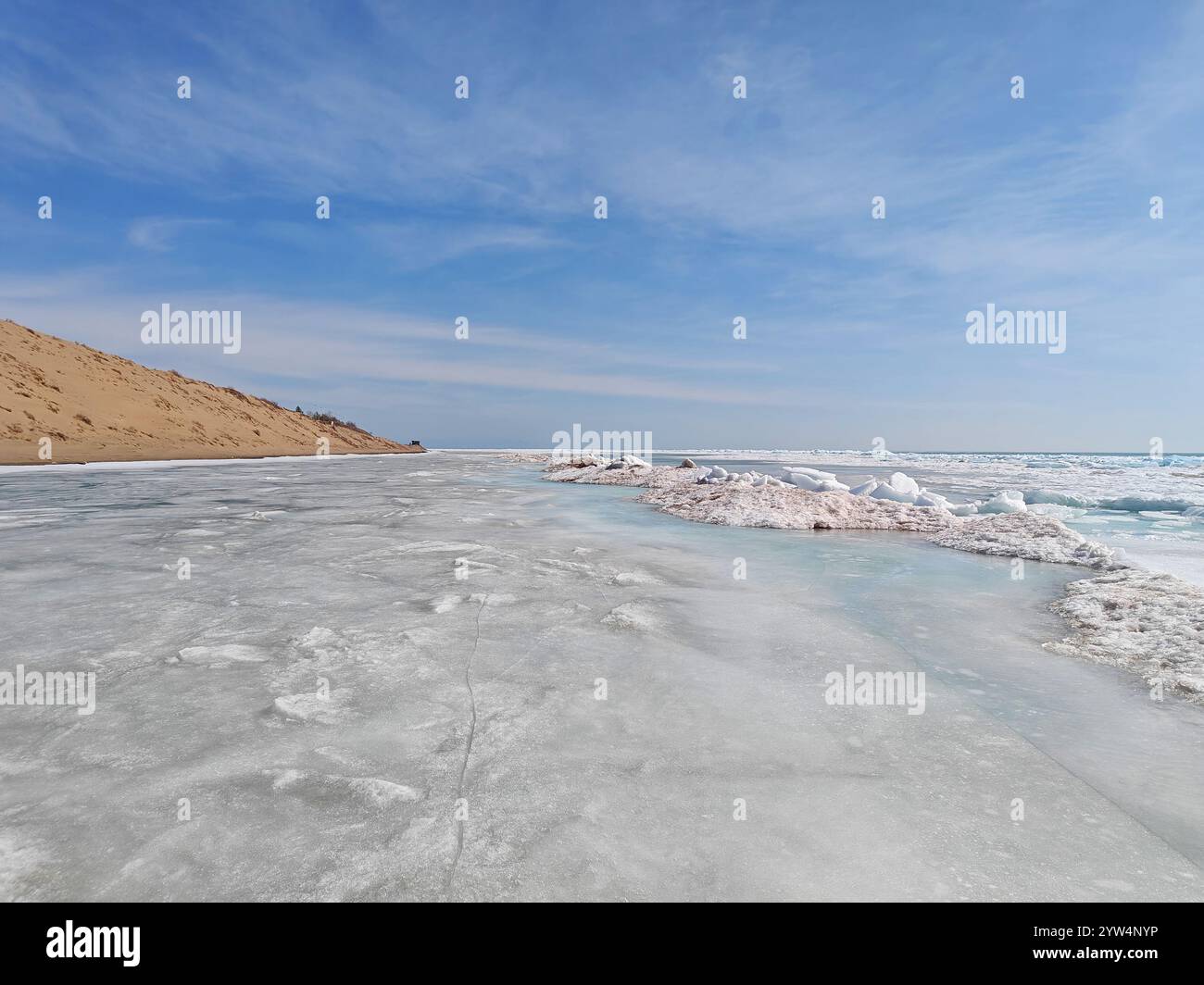 Frozen landscape showcases icy layers along a beach with ice chunks ...