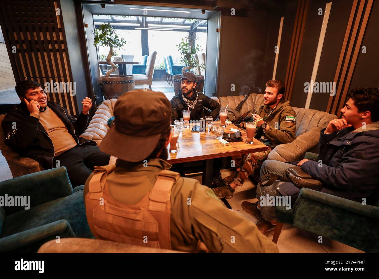 Syrian opposition fighters drink a coffee at a coffee shop in Damascus ...