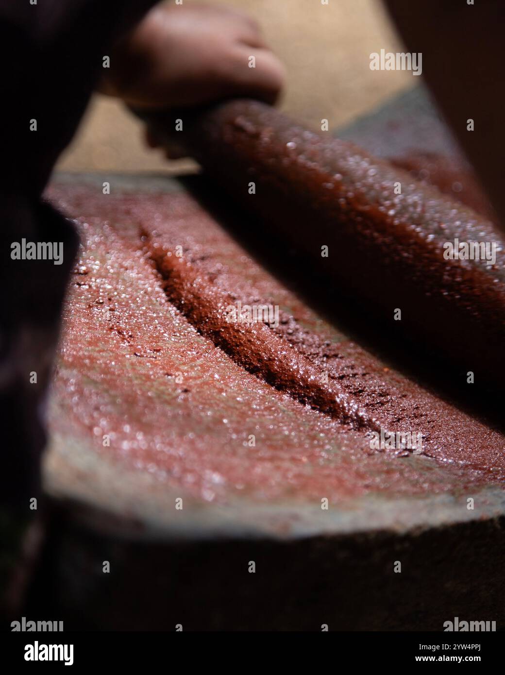 A woman in Oaxaca Mexico manually producing organic chocolate on a ...