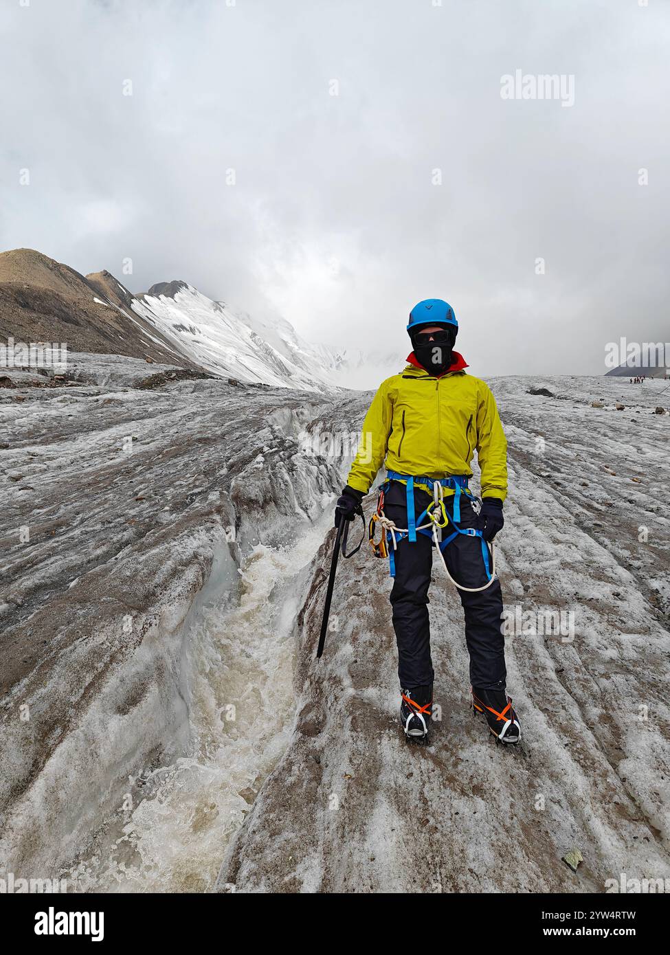 A climber stands on a glacier, equipped for a challenging ascent in ...