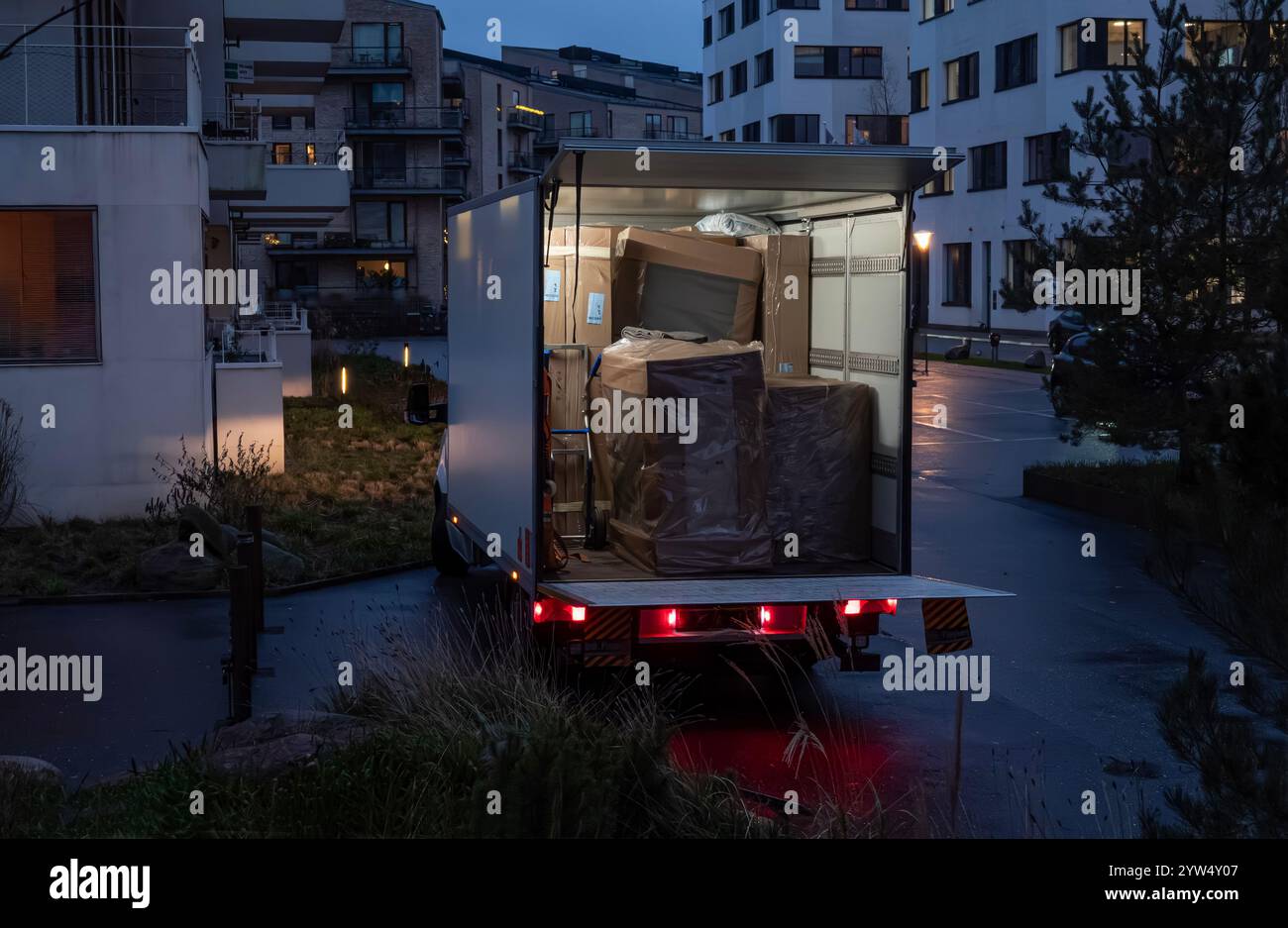 Delivery truck being at night with tailgate loader open in front of a ...