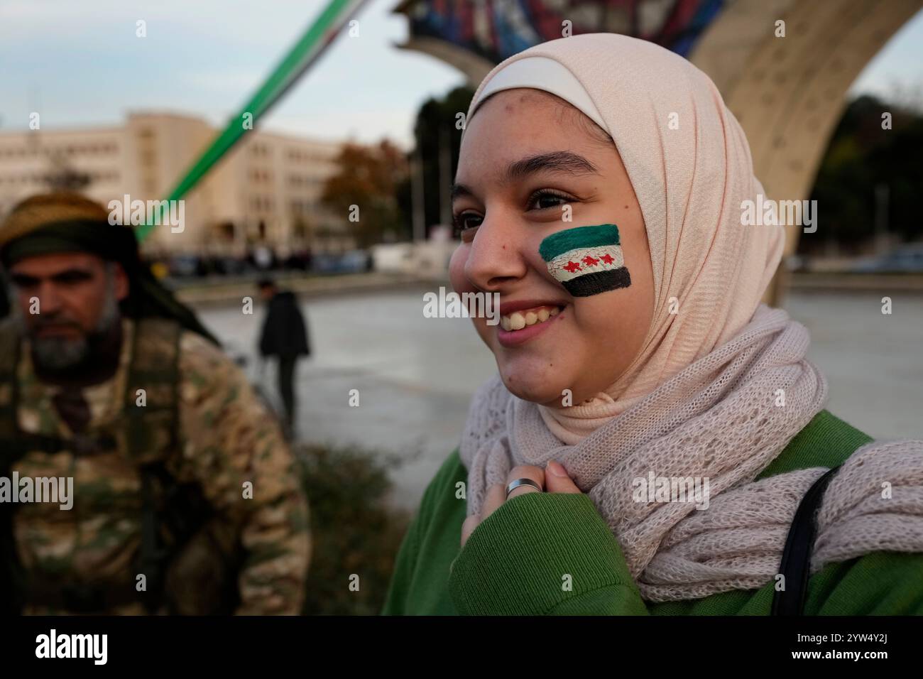 A Syrian girl with the revolutionary flag painted on her face, smiles ...