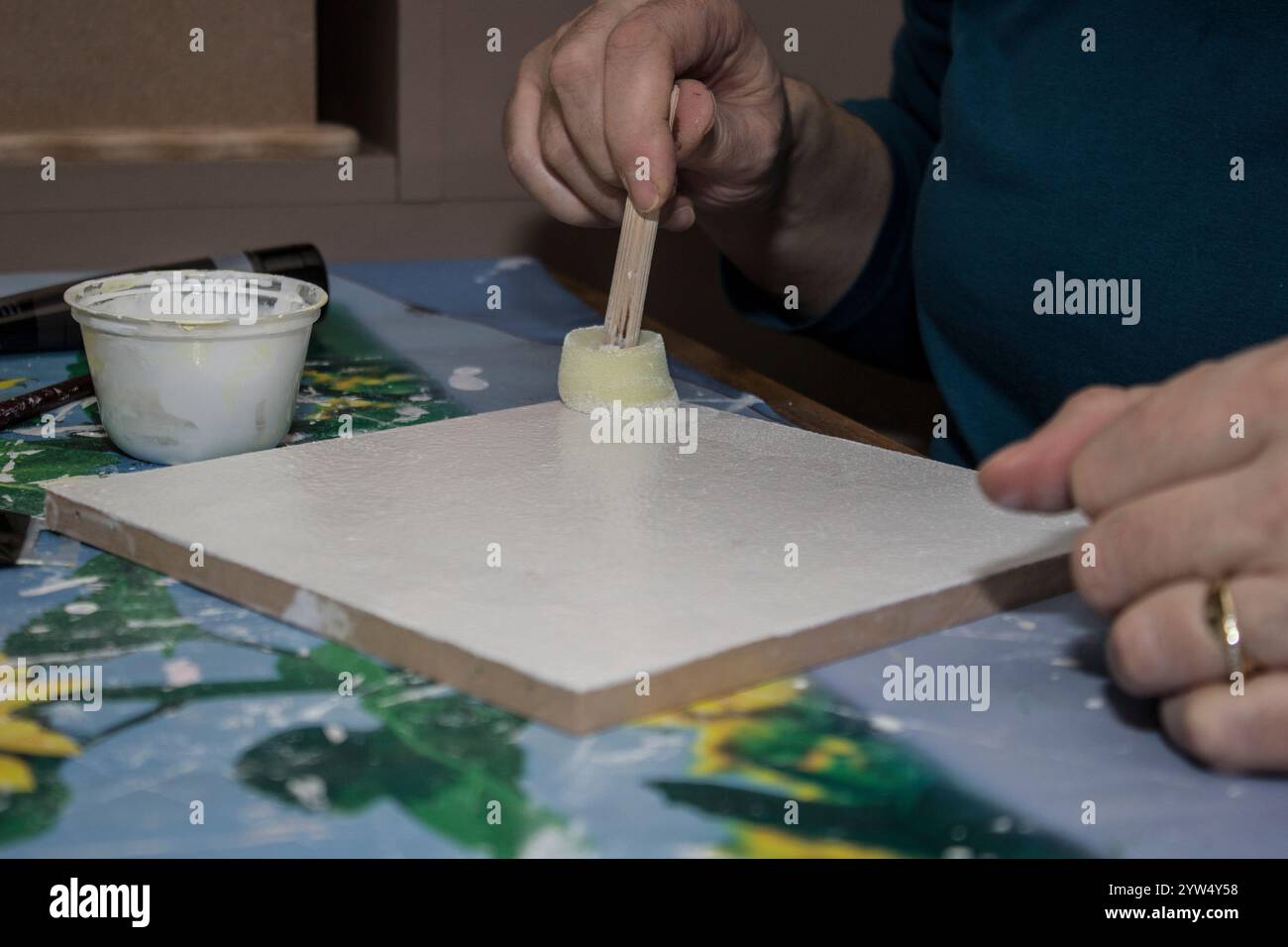 Applying paint to canvas with a brush Stock Photo - Alamy
