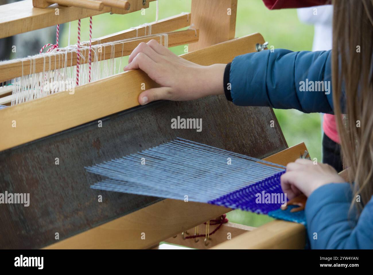 Weaving on a loom at a craft fair Stock Photo - Alamy