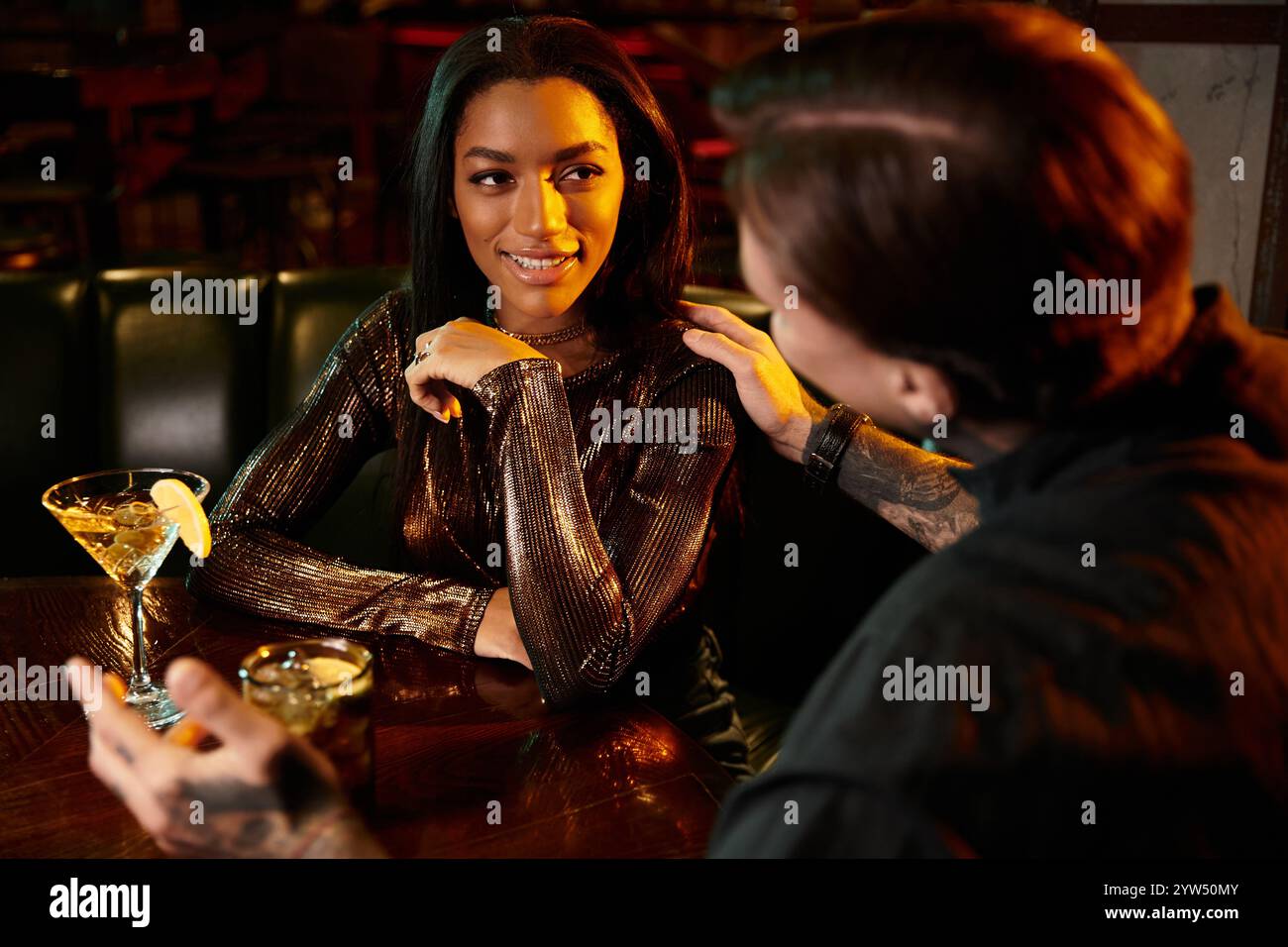 A young couple shares laughter and connection at a lively bar during a ...