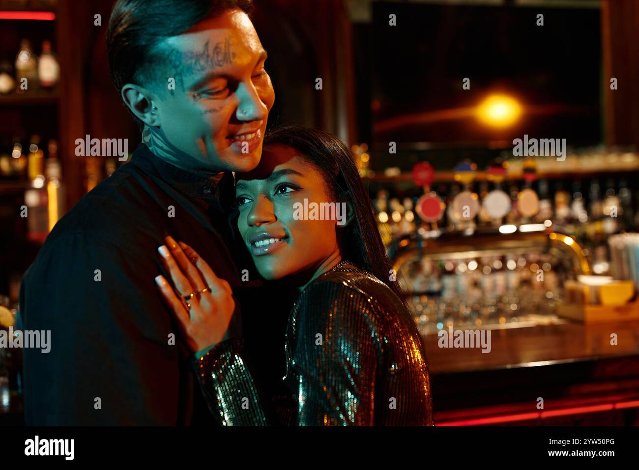 A young couple shares laughter and affection in a lively bar ...