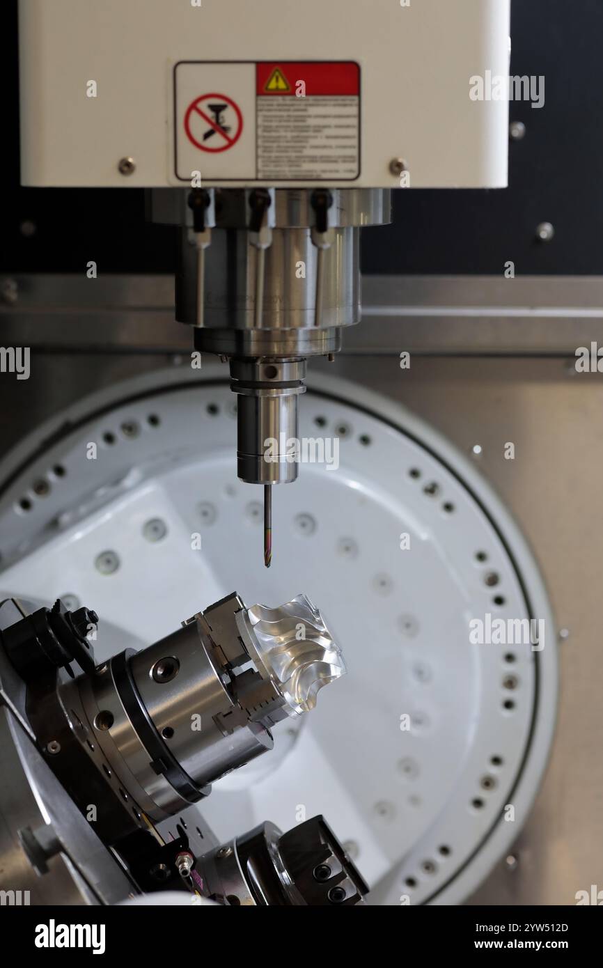 Close up of 5 axis vertical CNC machining center with rotary table. Turbine wheel manufacturing ...