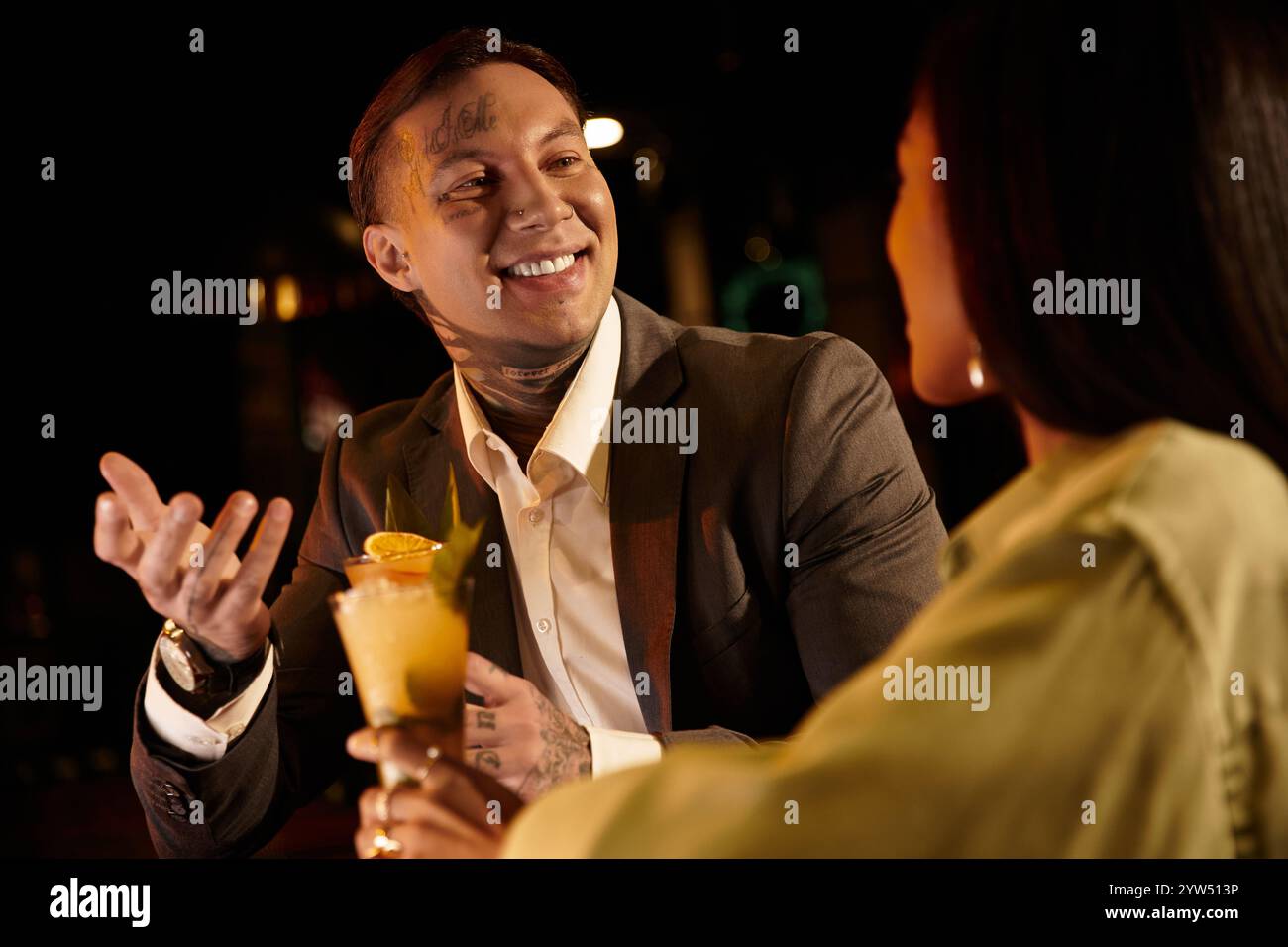 Tattooed young couple shares laughter and drinks during a delightful ...