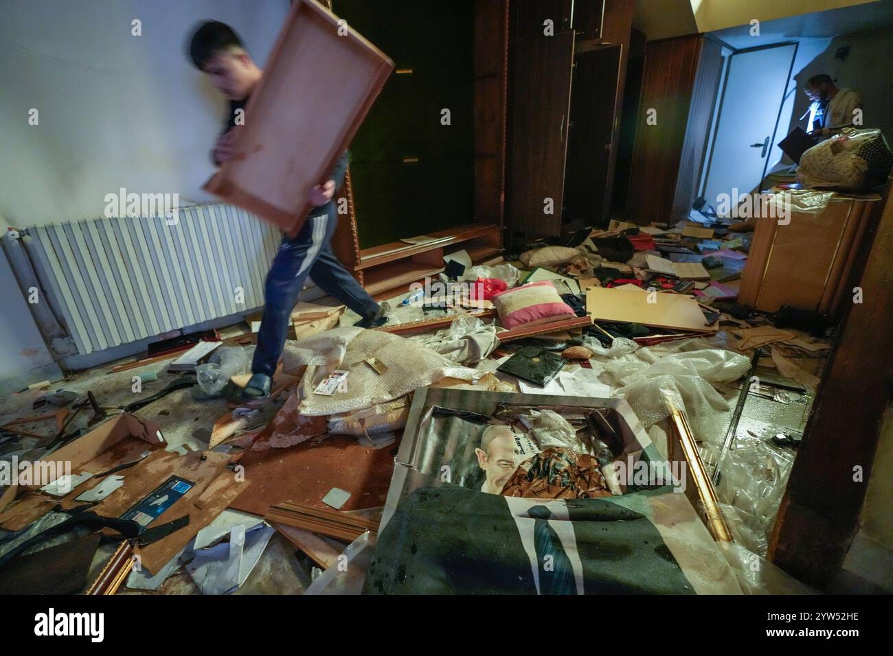 FILE - A man walks by a smashed portrait of the late Syrian President ...