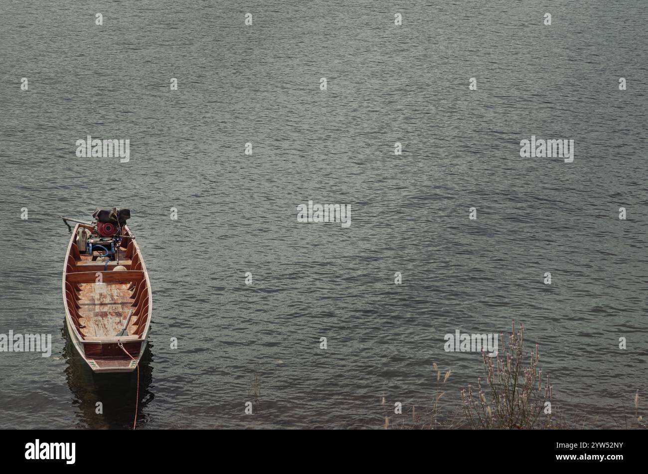 Traditional hand built small wooden rowboat slowly in warm evening ...