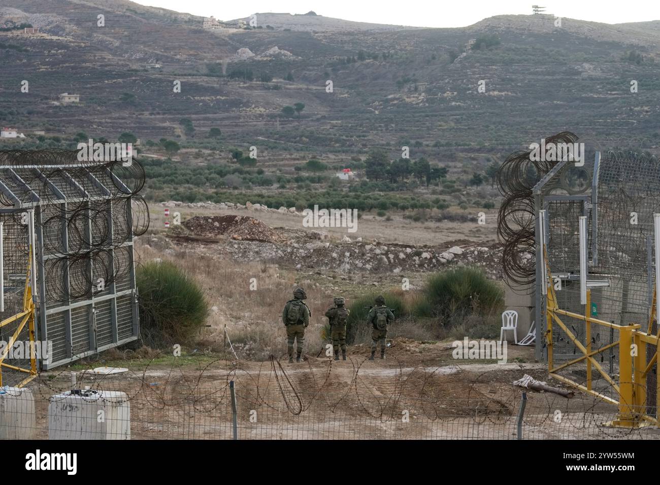 Israeli soldiers stand guard on a security fence gate near the so ...
