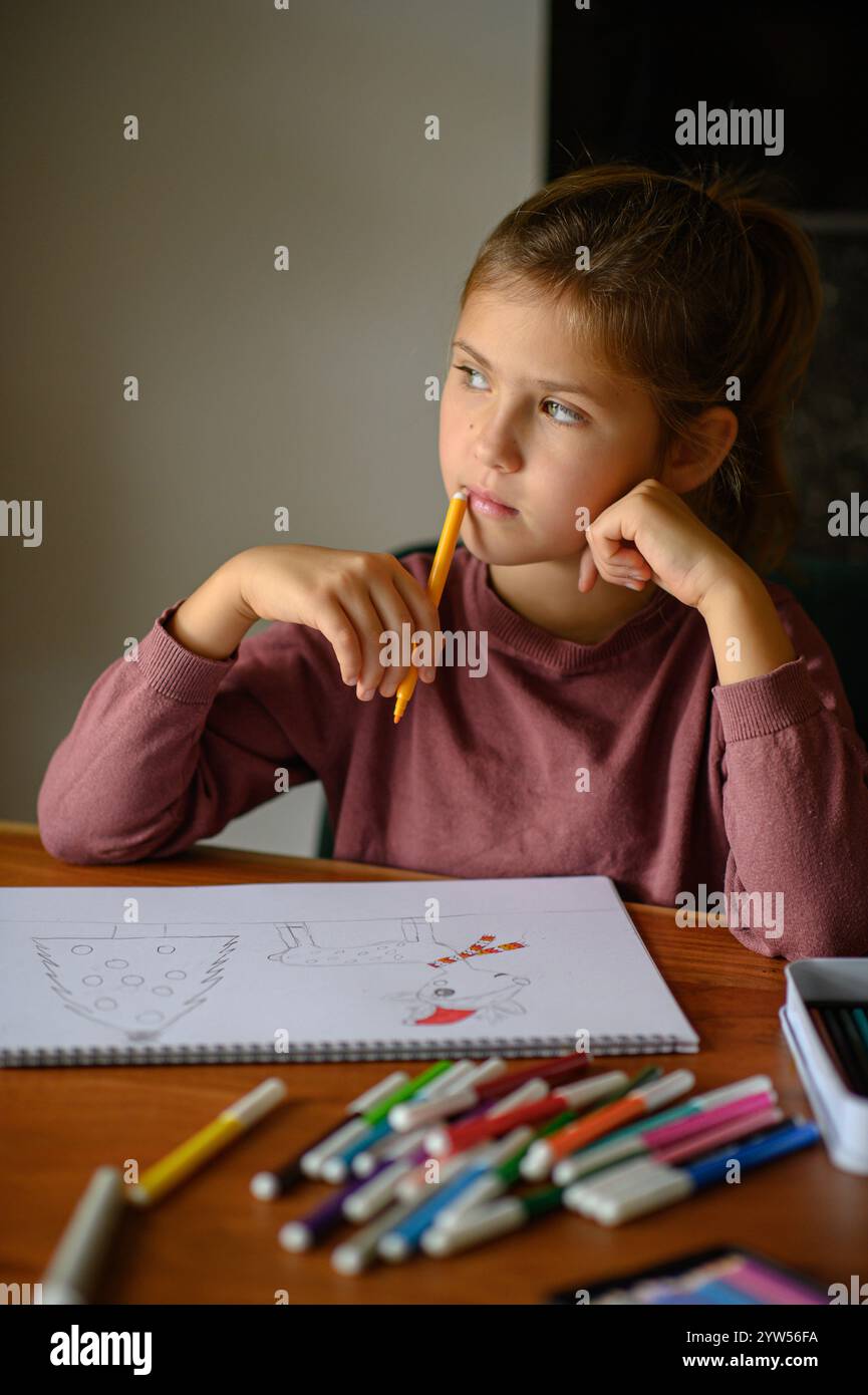 girl is sitting on the table she is studying painting and reading with ...