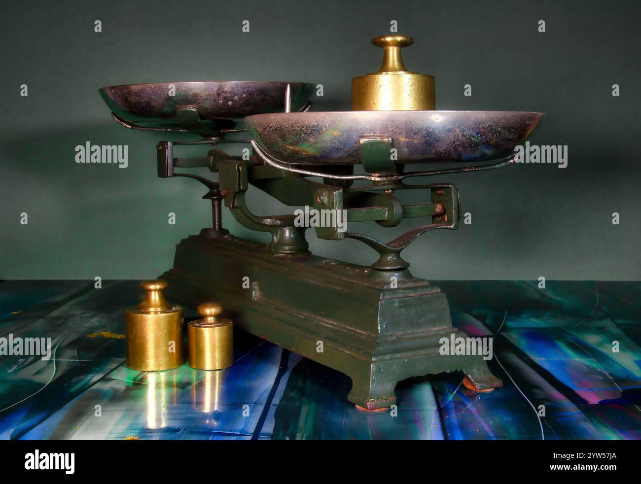 A set of vintage balance weights on a reflective coloured surface ...