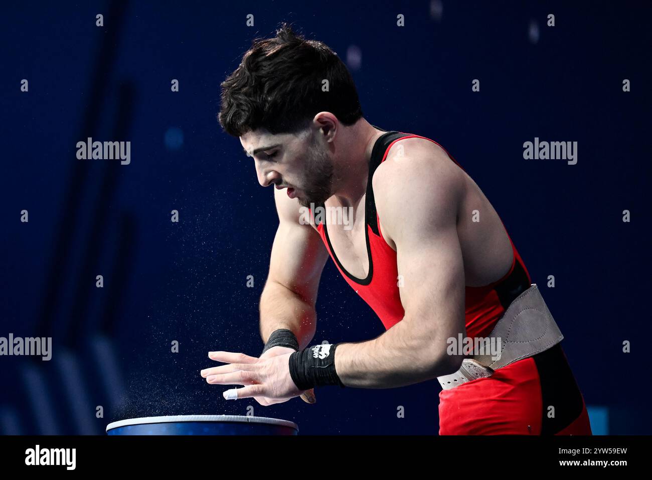 Garnik Cholakyan of Armenia competes in clean & jerk, in the 61 kg men ...