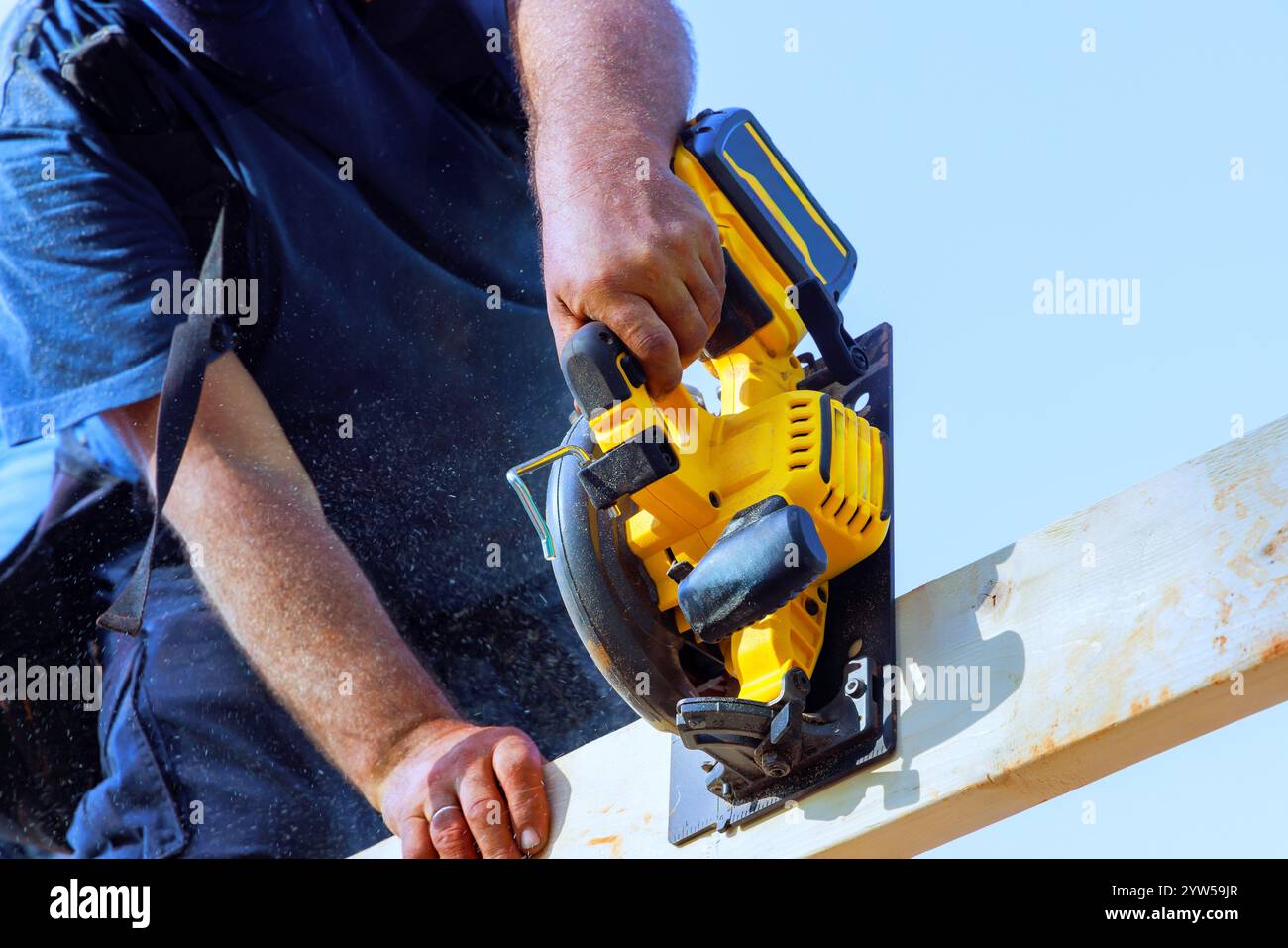 Skilled worker operates circular saw, cutting wood frame on under ...