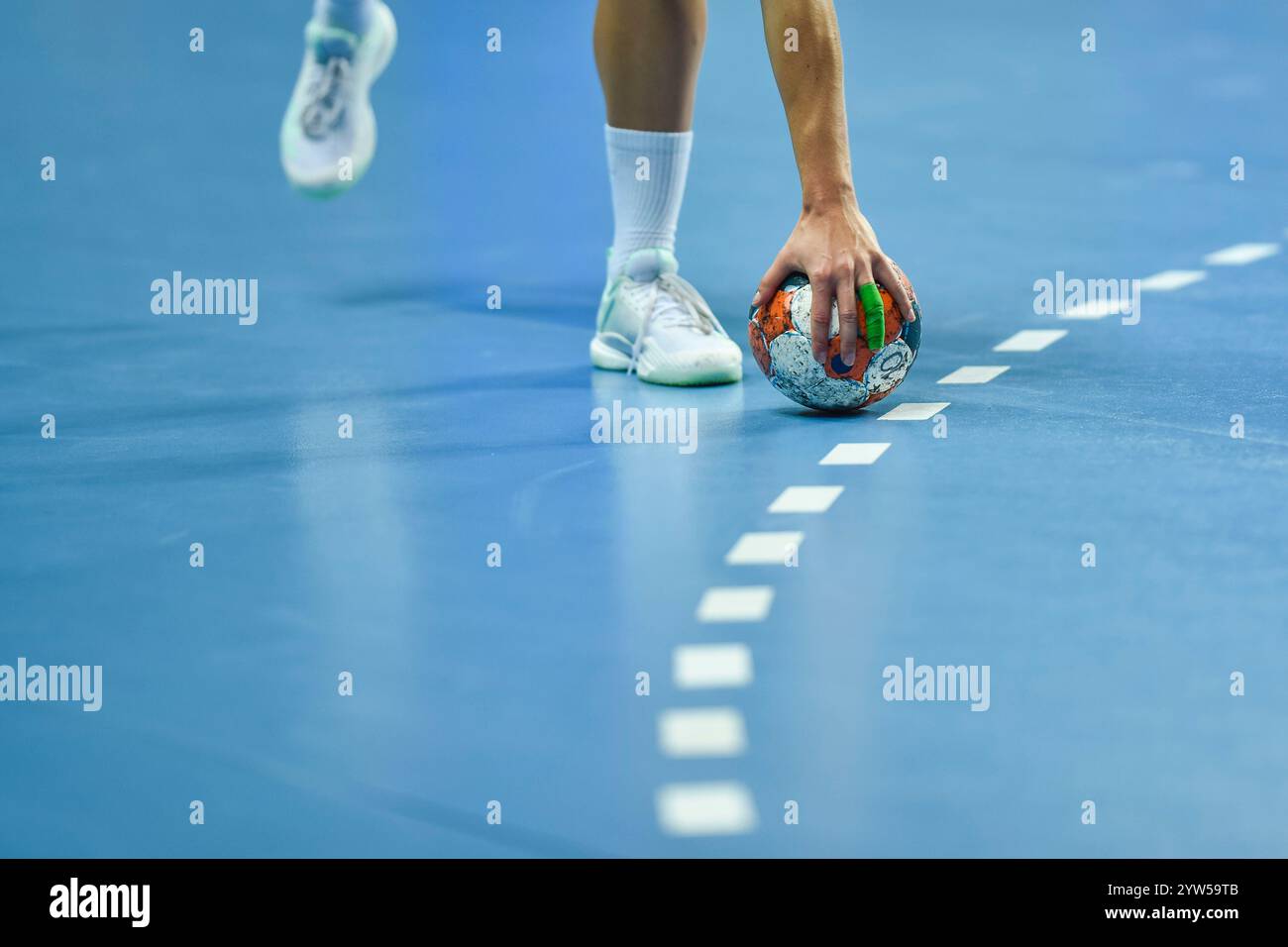 Handball - women's hand taking a ball laying on the 9 meters dotted ...