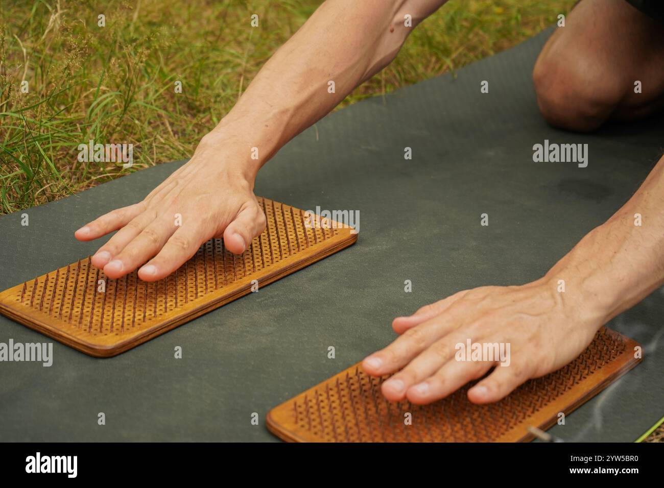 Close-up of a person's hands on a sadhu board, palms down. The nails in ...