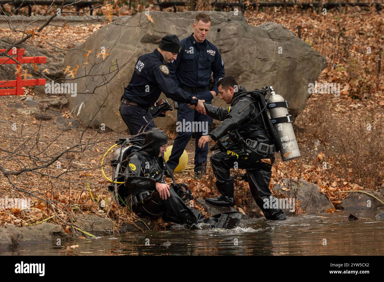 NYPD officers in diving suits sit after searching the lake in the ...