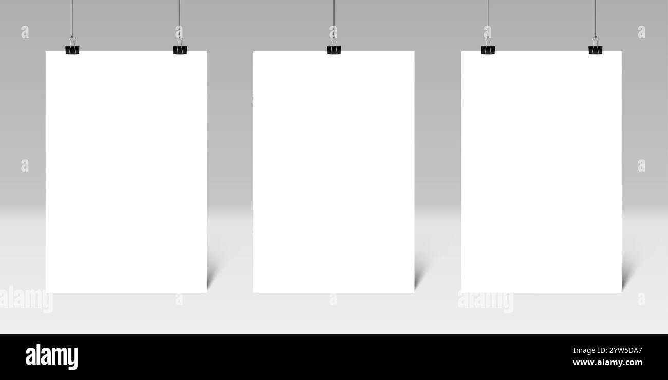 Three blank vertical posters hanging from binder clips on a gray wall ...
