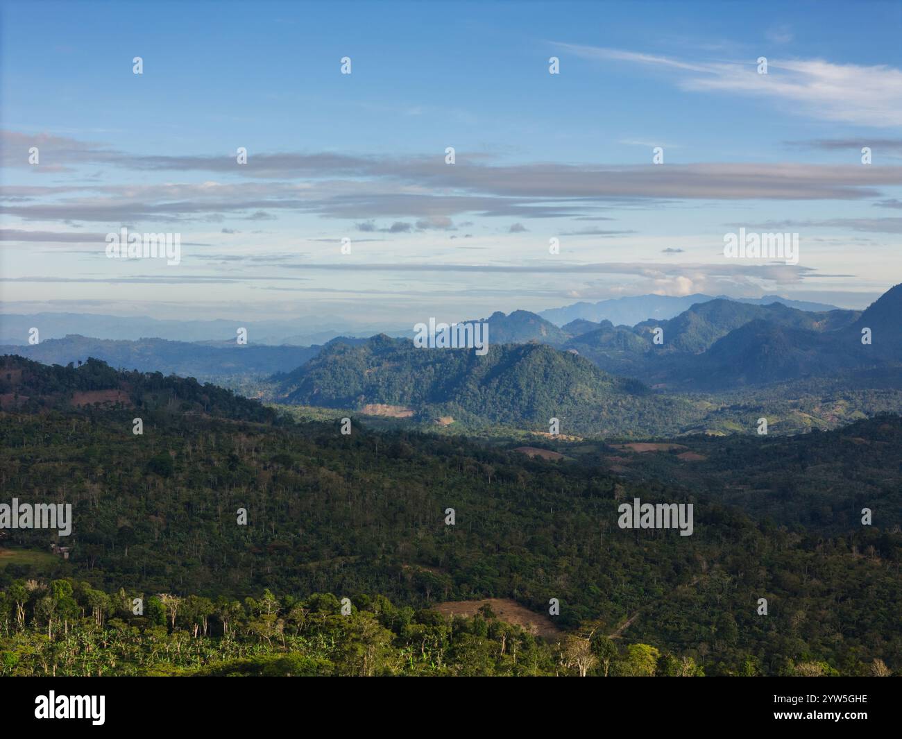 Lush green hills and mountains stretch across horizon under bright blue ...