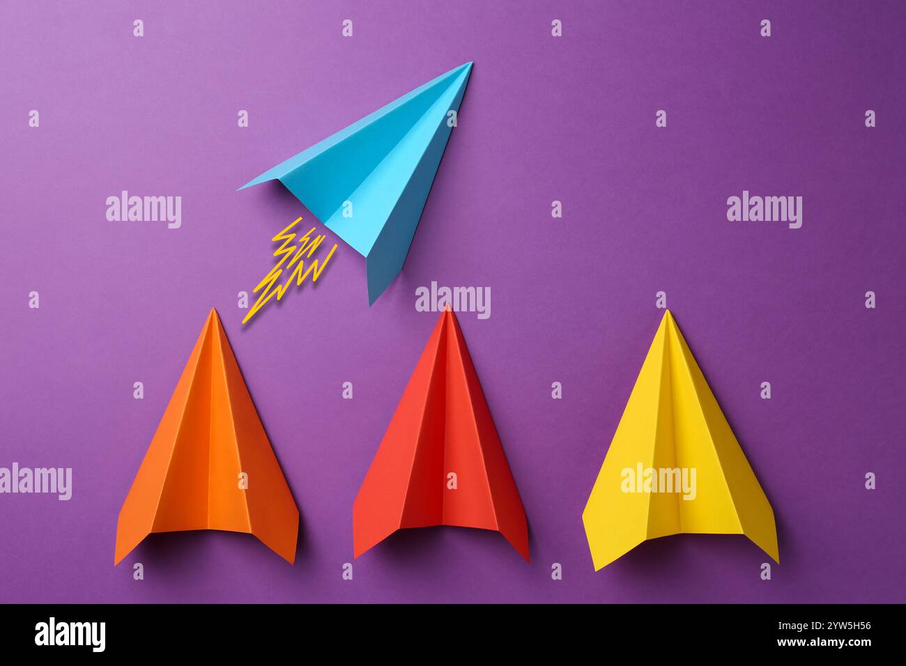 Light blue paper plane bursting forward among others on purple ...