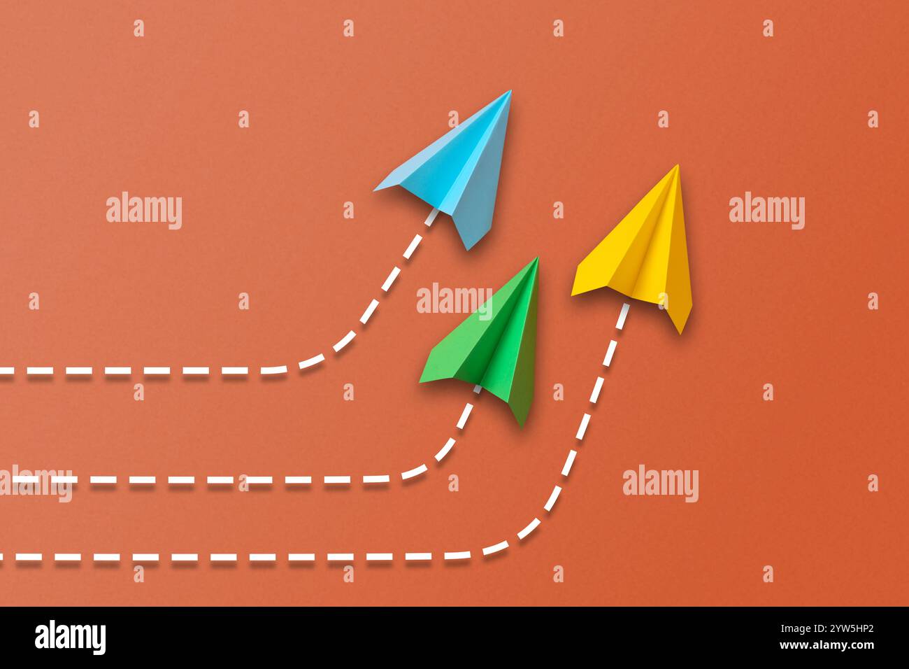 Colorful paper planes with flight paths on orange background. Dashed ...