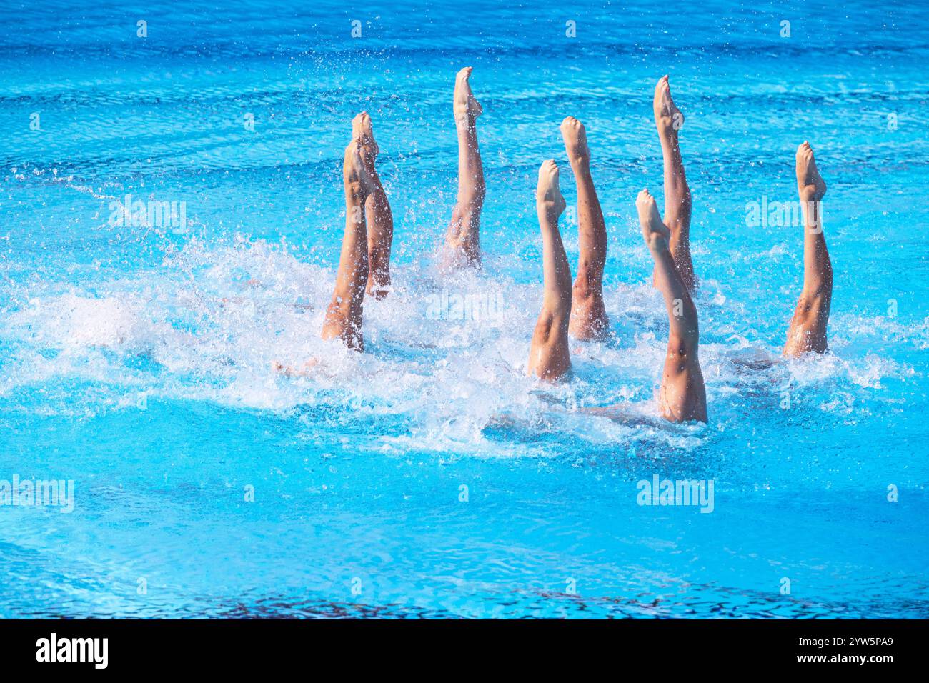 Artistic swimming team performing synchronized choreographed routine in ...
