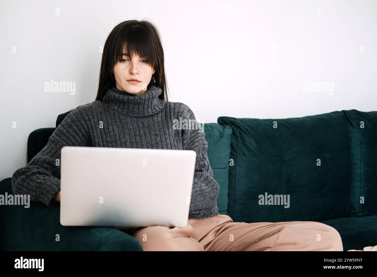 Woman working remotely on laptop, addressing mental health and ...