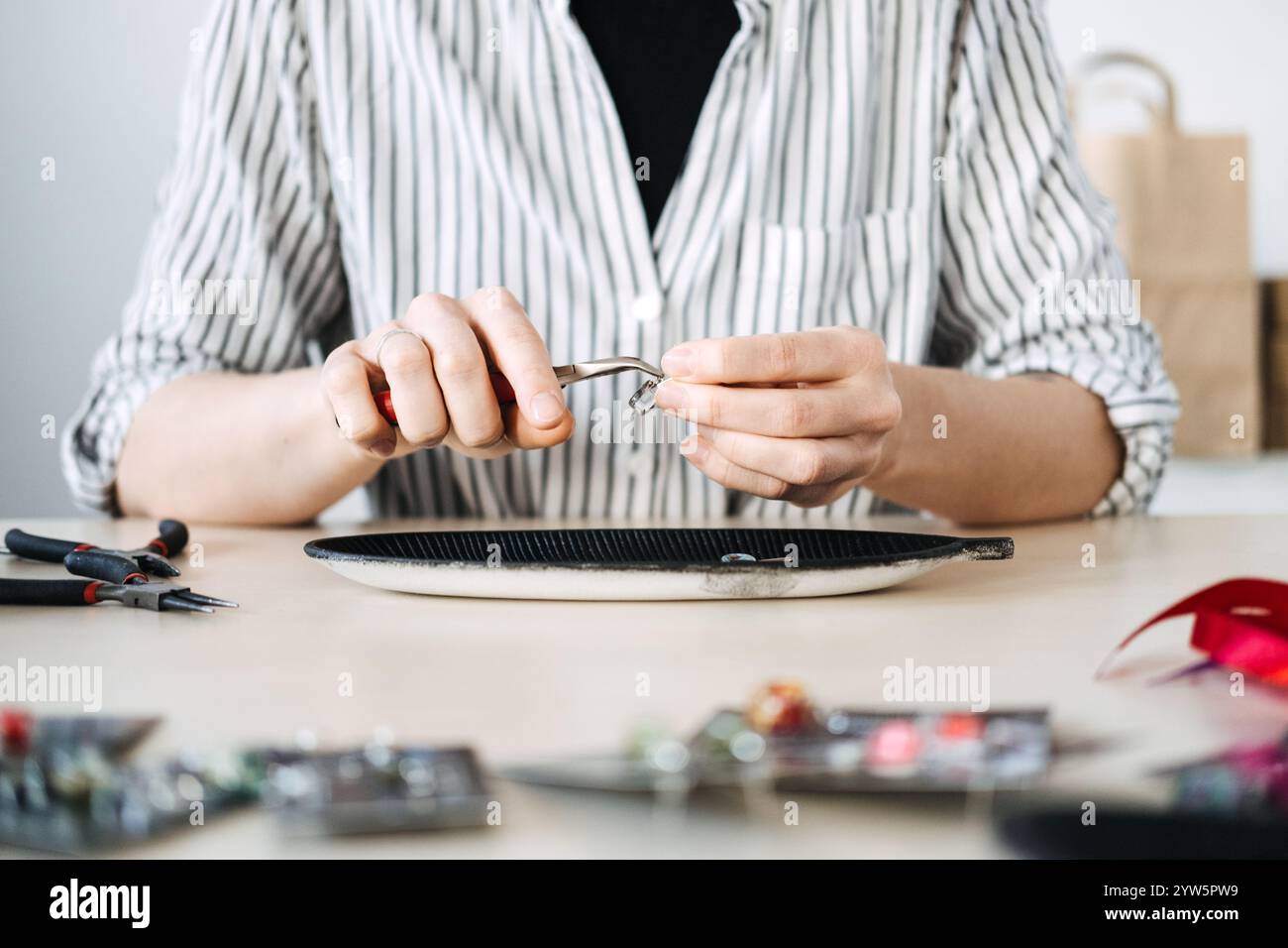 Hands crafting handmade jewelry with pliers and beads. Capturing ...