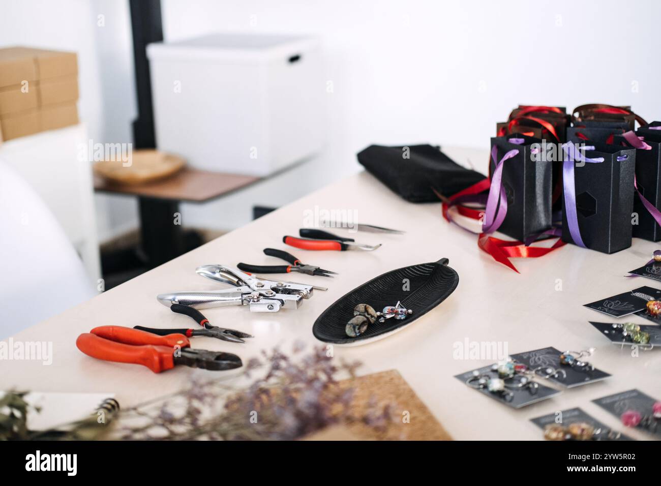 Artisan jewelry-making setup with colorful gift bags. Highlighting the ...