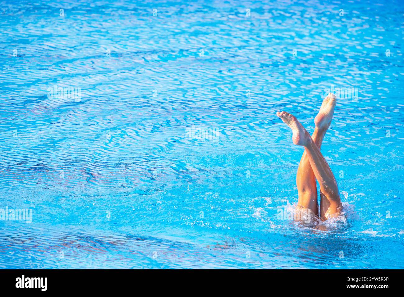 Female artistic swimmer performing choreographed legs movement in the ...