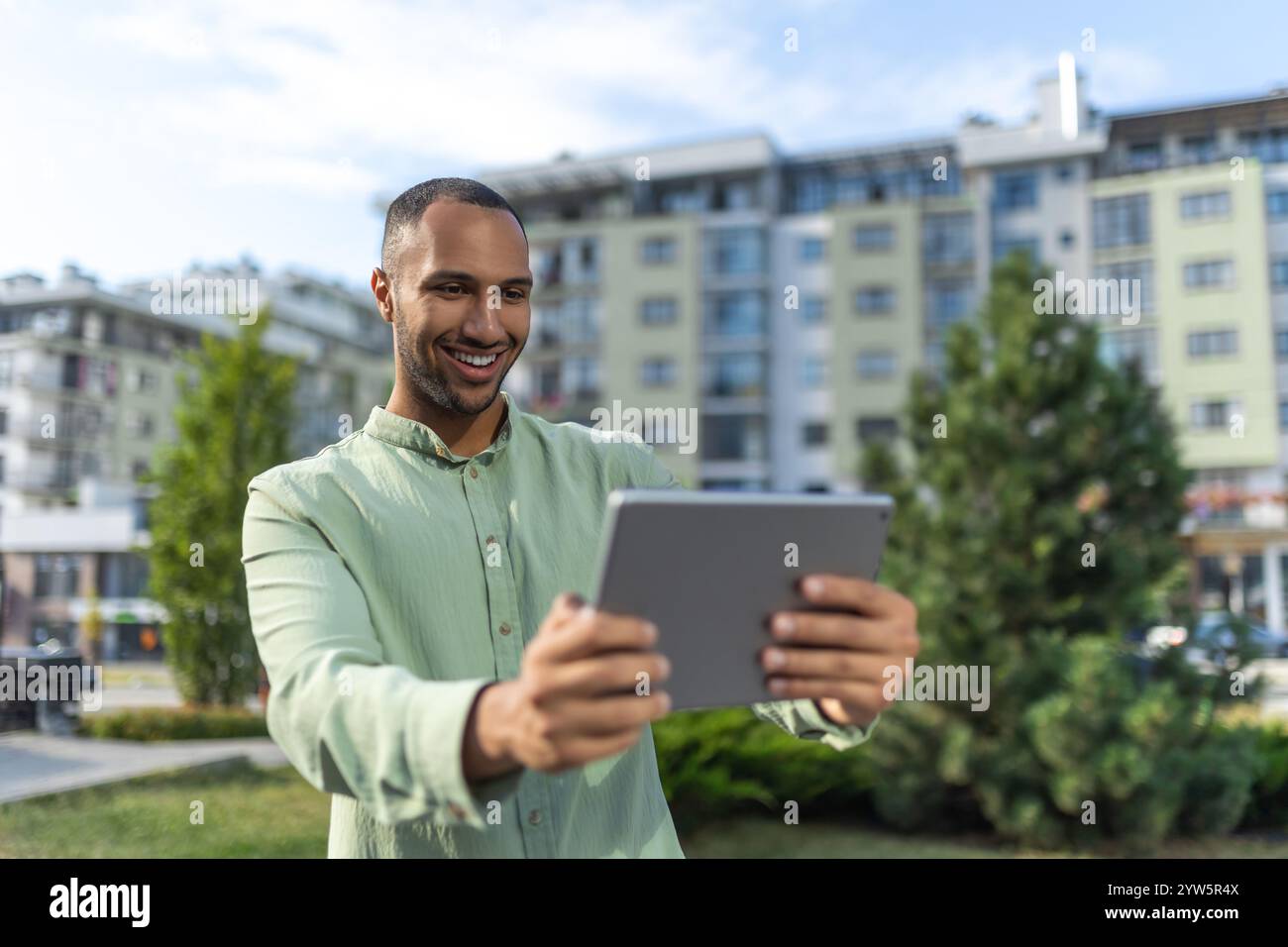Businessman with tablet standing near buildings checking built project ...