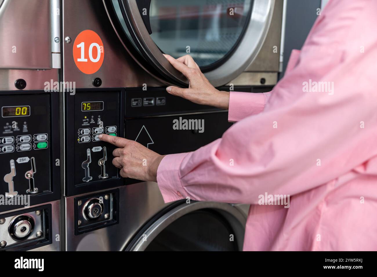 Close up picture of female hand programming washing machine Stock Photo ...