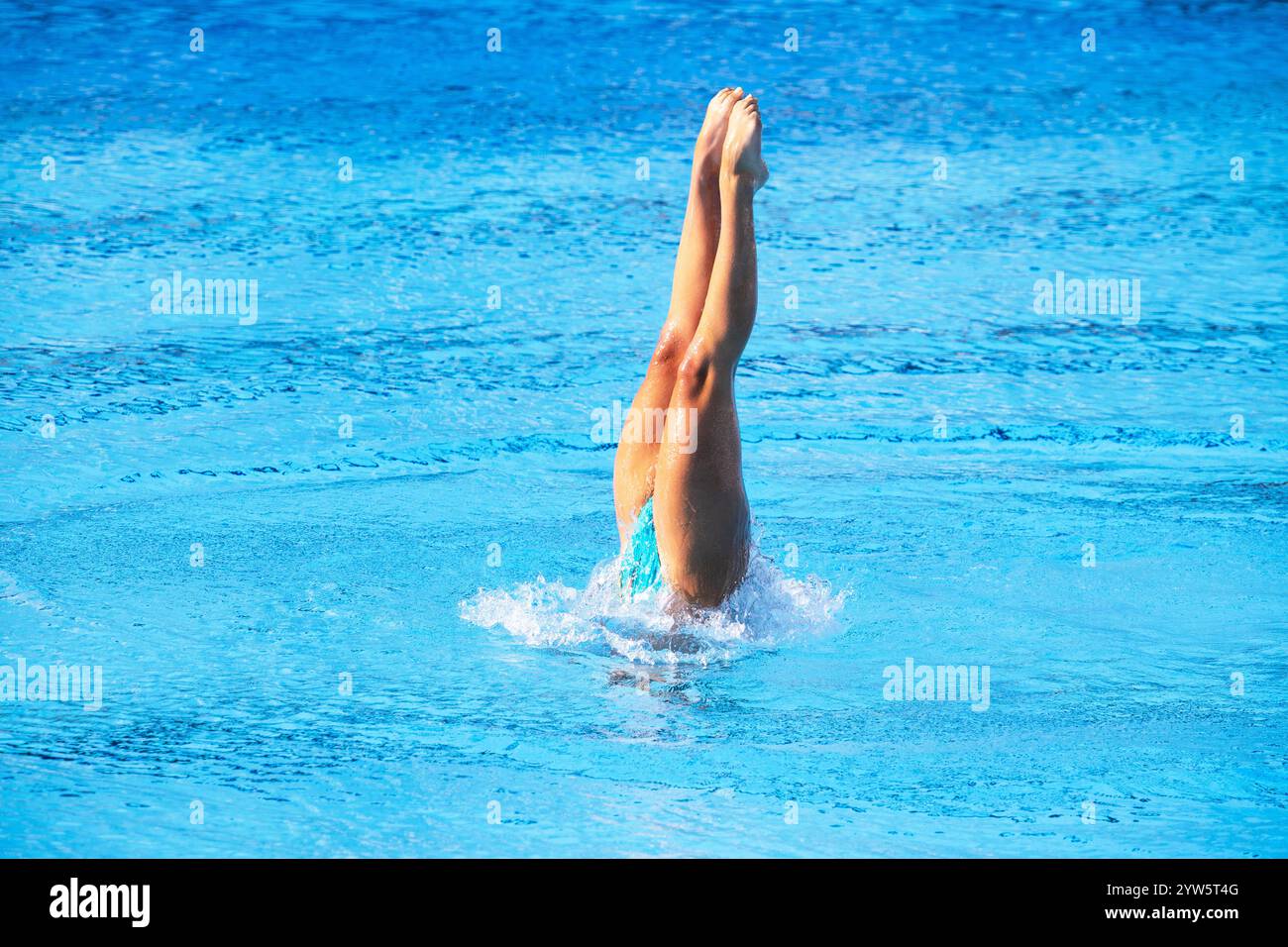 Female artistic swimmer performing choreographed legs movement in the ...