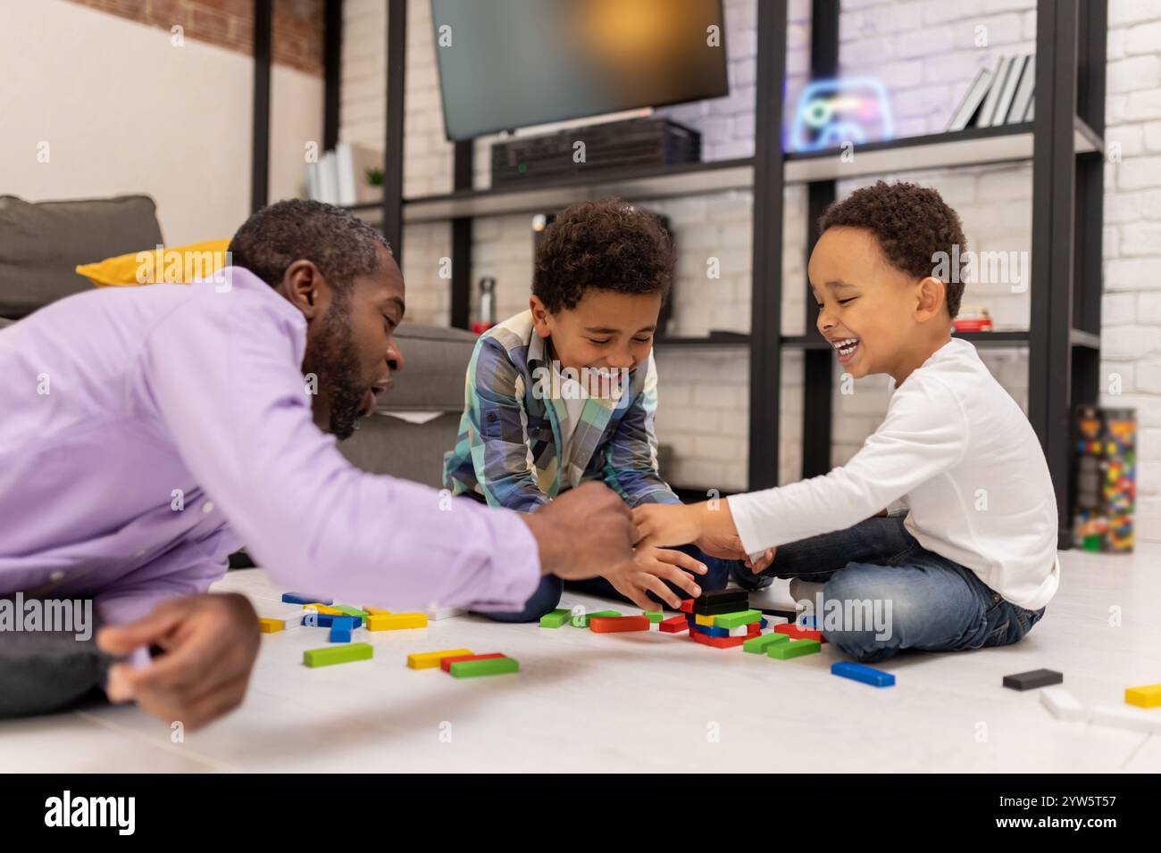 Kids and their dad playing jenga on the floor Stock Photo - Alamy
