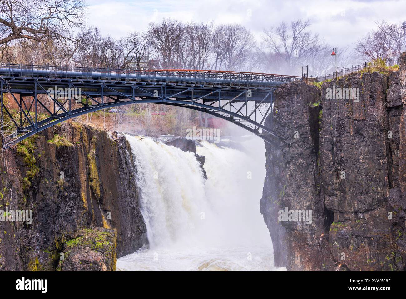 Great Falls waterfall and steel arch bridge surrounded by misty spring ...